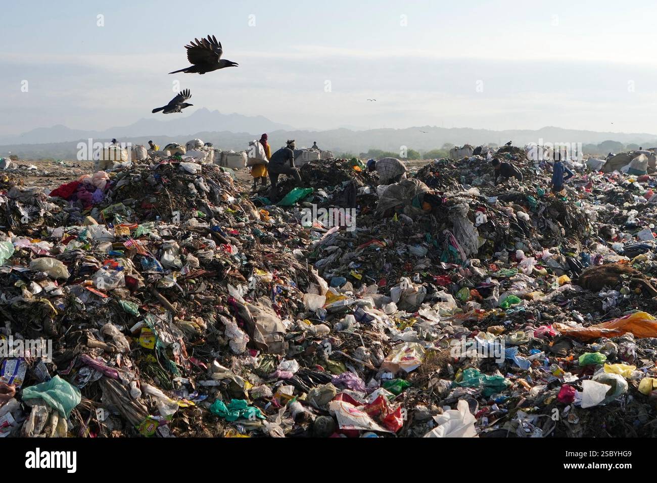 FILE - Indian rag pickers look for reusable material at a garbage dump ...