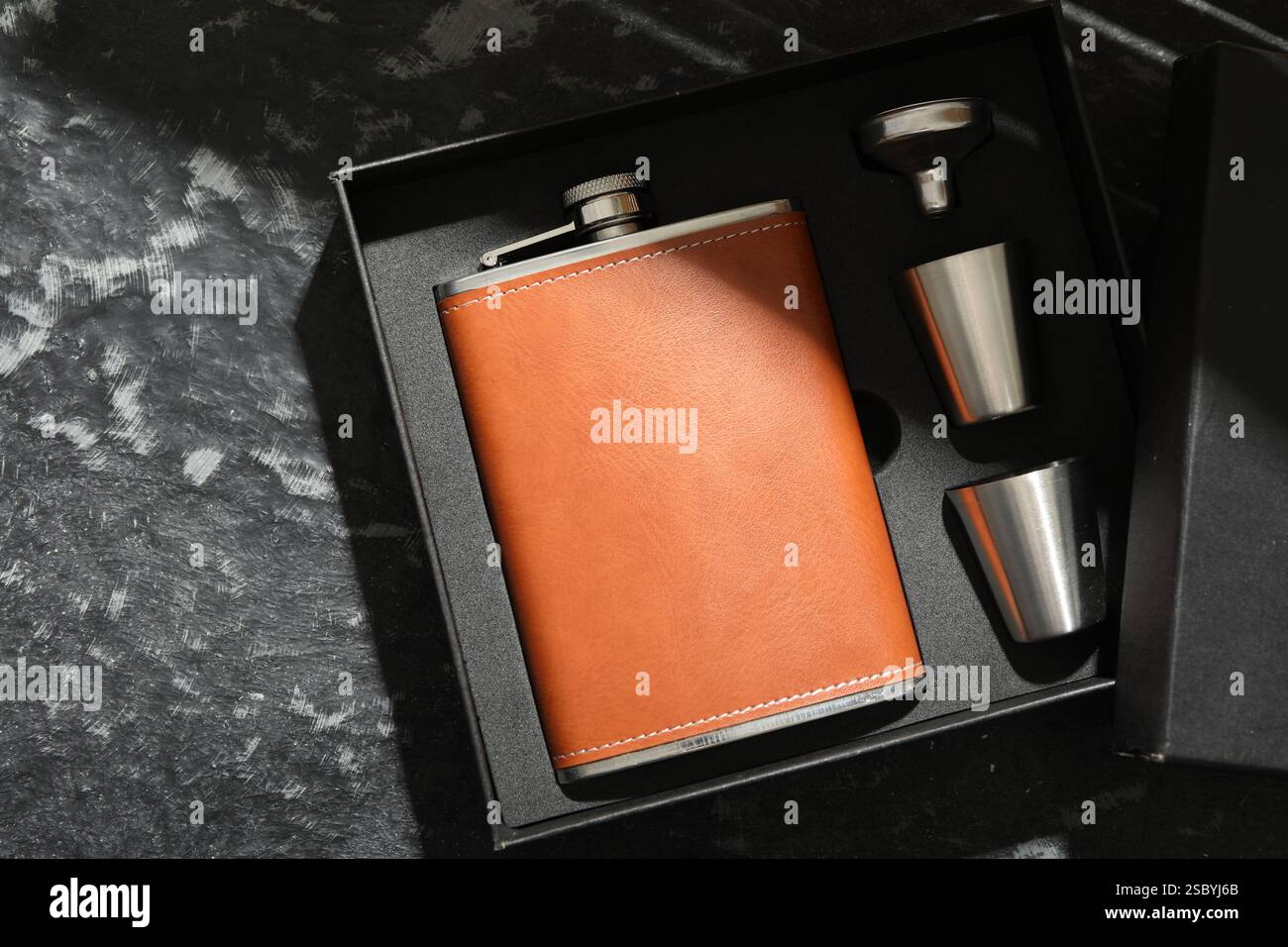 Hip flask, cups and funnel in package on dark table, top view Stock ...