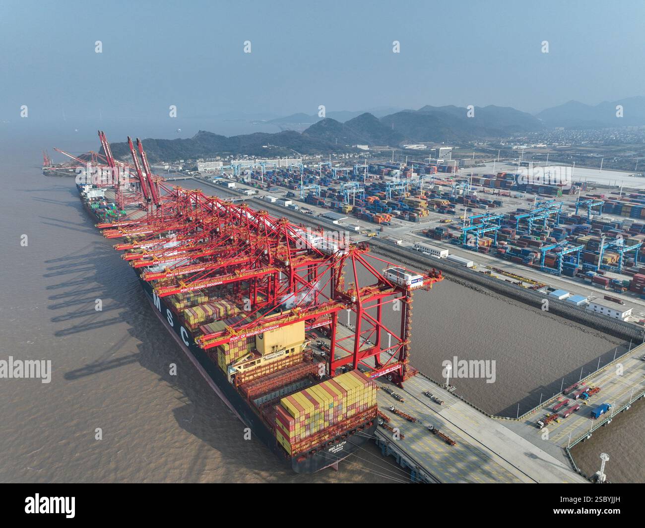 Cargo ships load and unload containers in an orderly manner at the ...