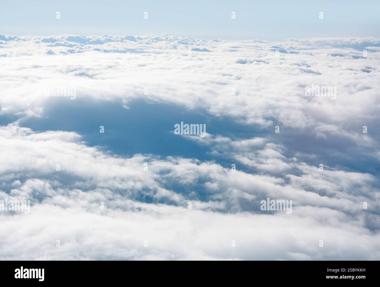 View from above of clouds stretch out as far as can see. Sky is full of ...