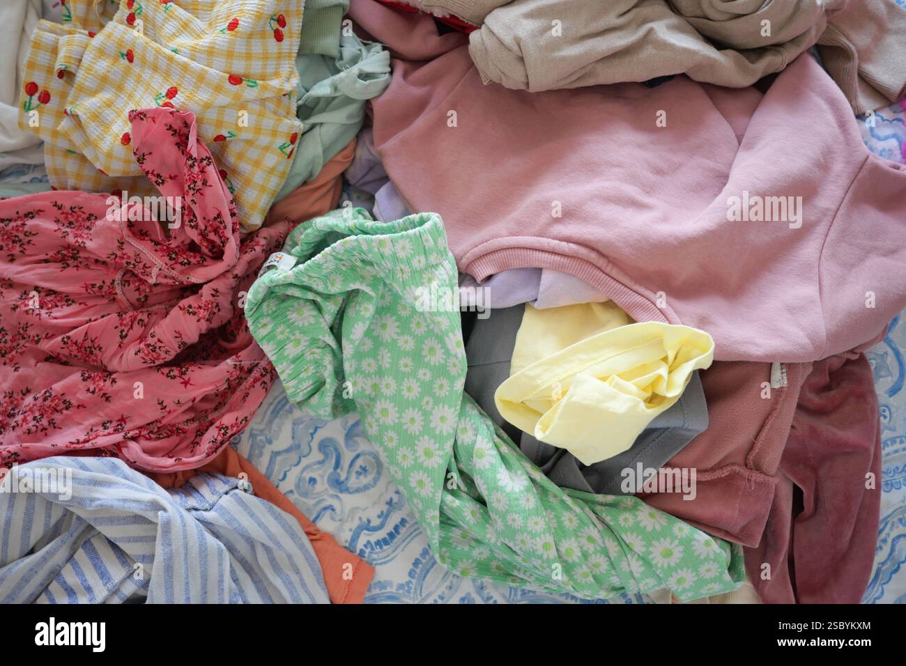Clothes piled on a bed after laundry day in natural light Stock Photo ...