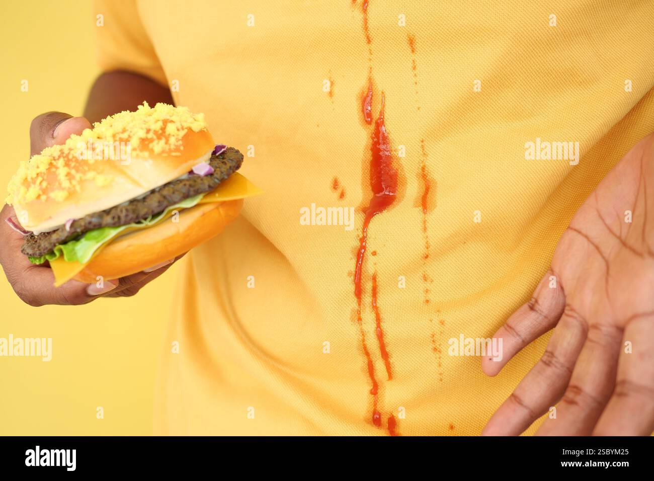 Dropped burger creates messy moment in bright yellow setting Stock ...