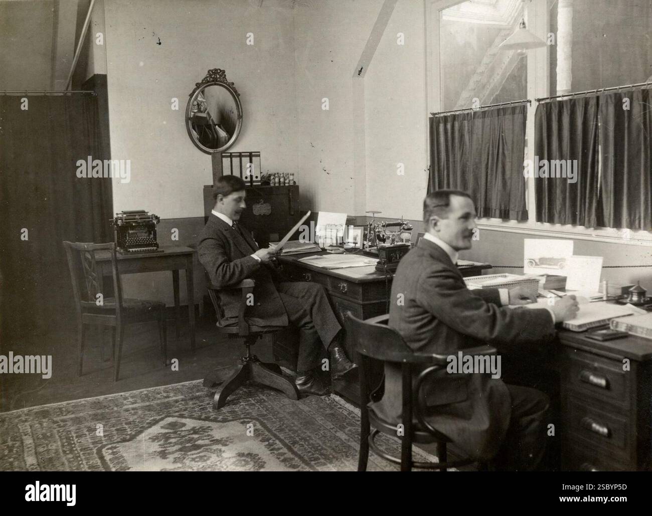 Het kantoor van Garage Bonarius met twee medewerkers aan hun bureau ...