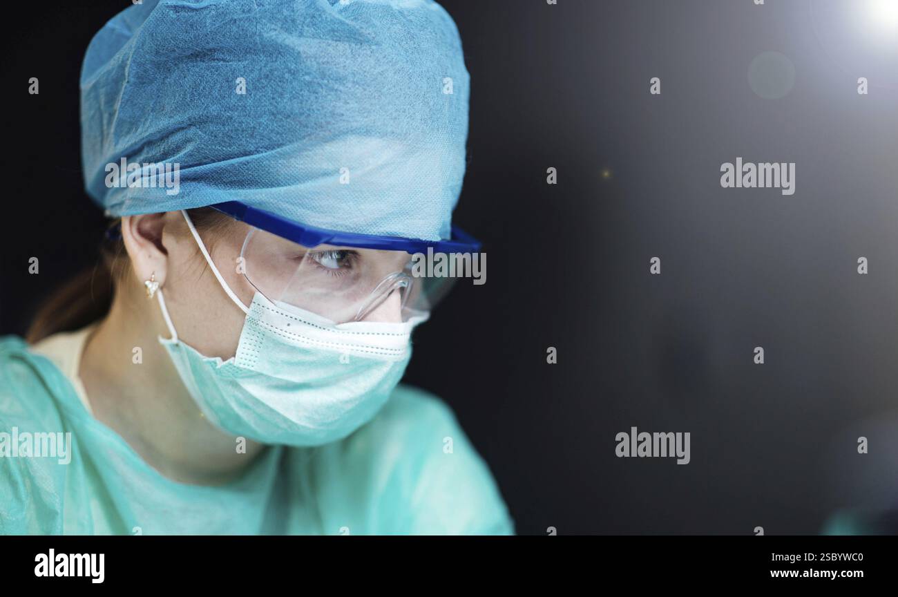 A medical professional wearing surgical attire focused on their work ...