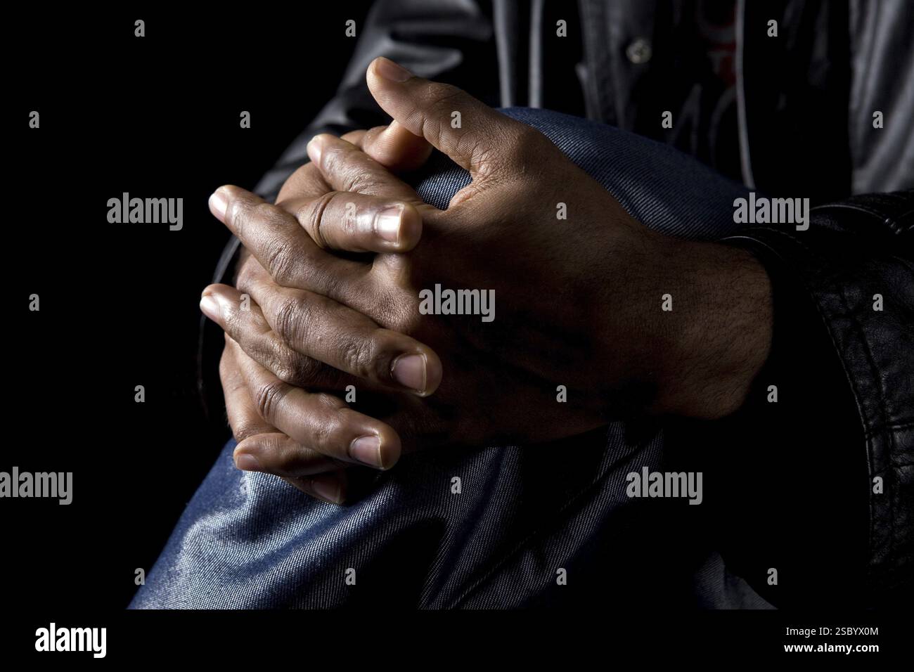 Sitting man her hands on knee Stock Photo - Alamy