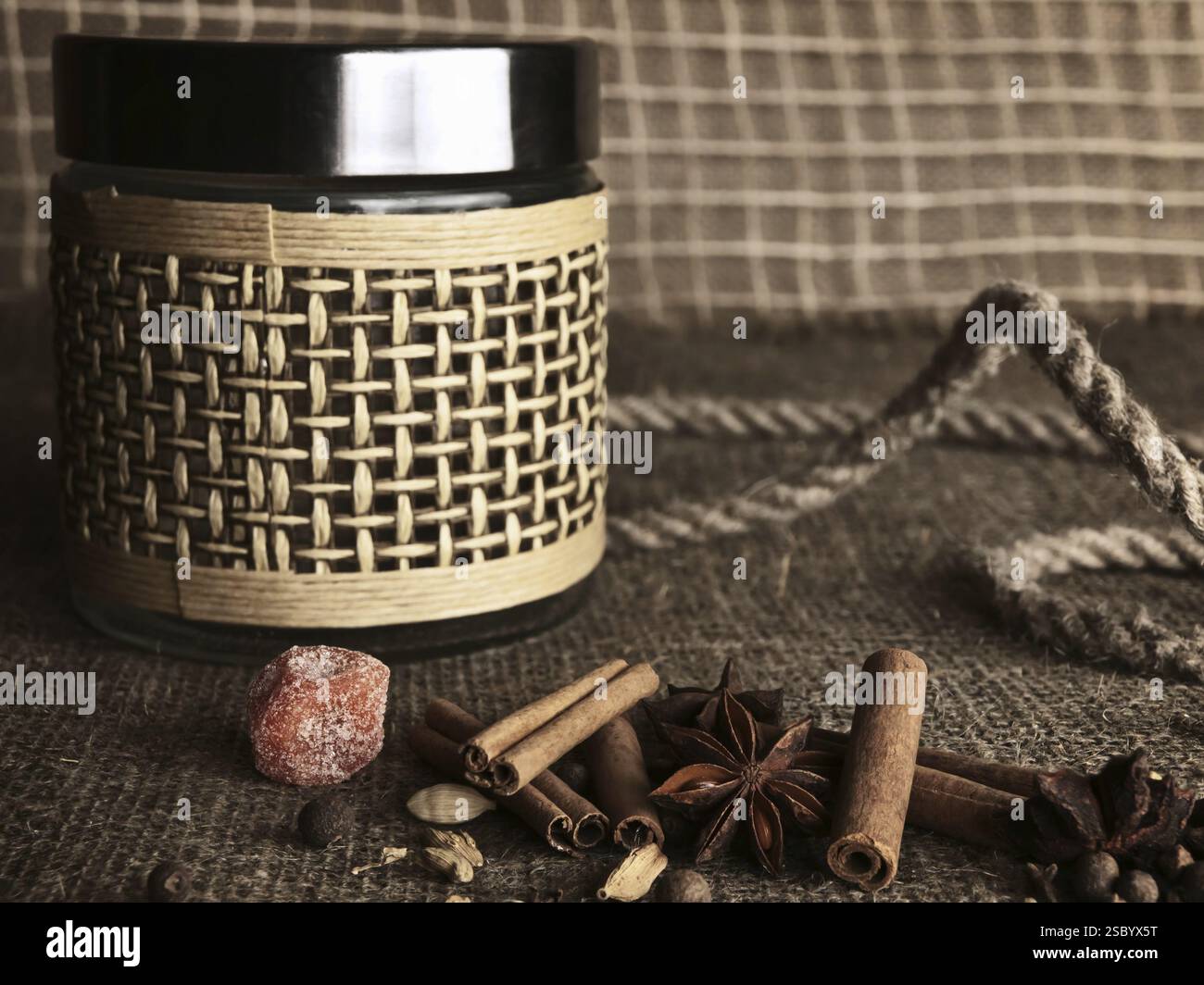 Spice mix for hot wine over the burlap background with glass jar ...