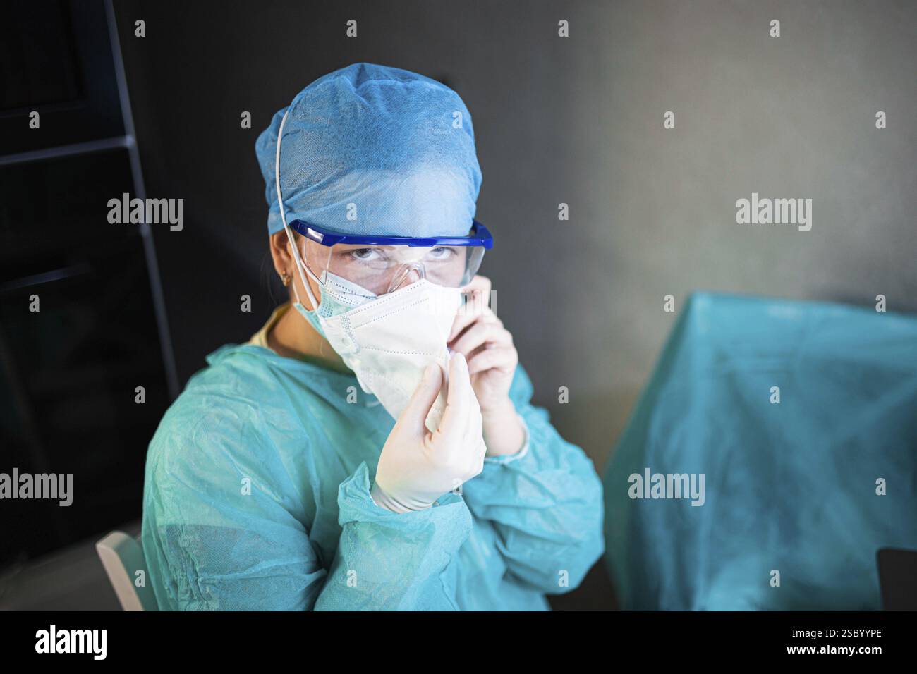 Medical staff adjusting a mask while wearing protective equipment Stock ...