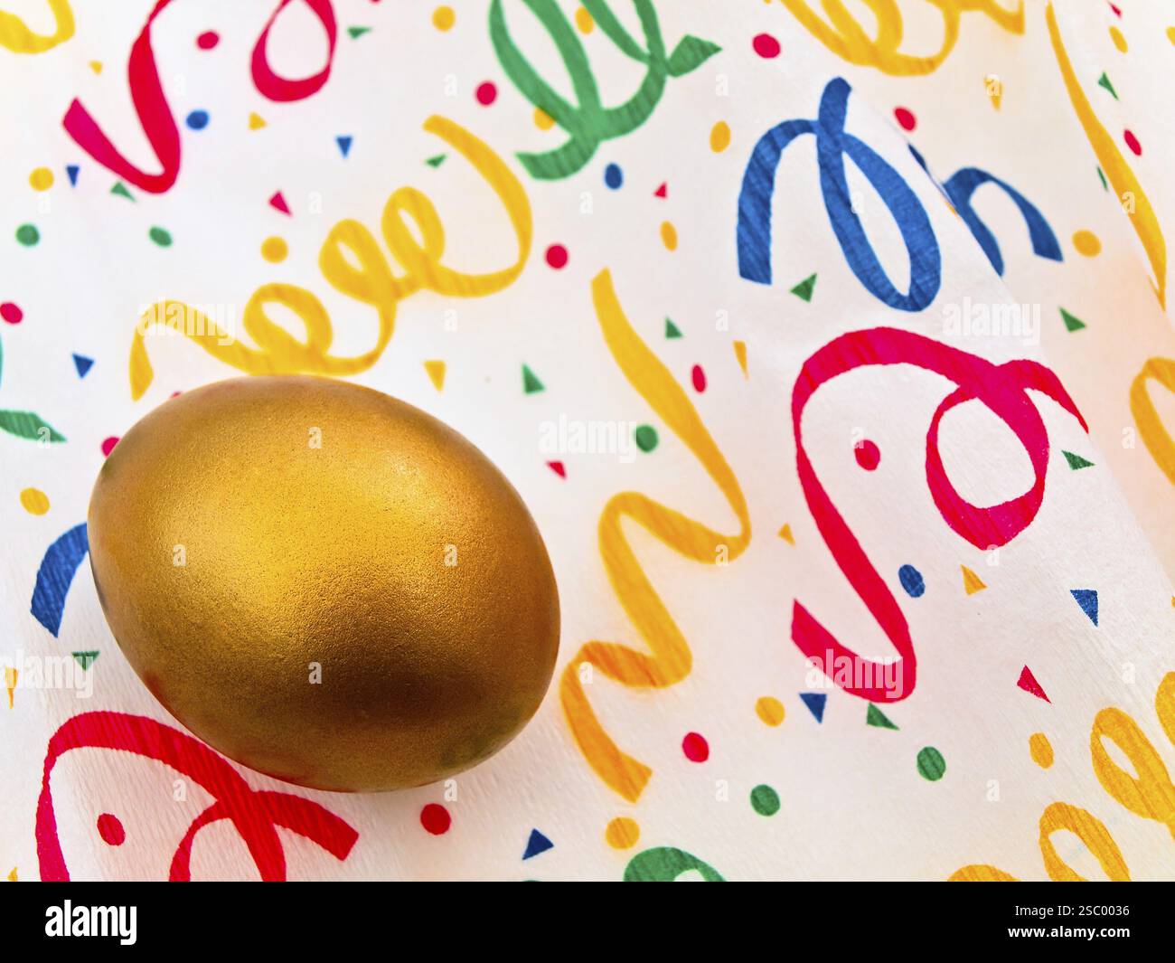 Single golden egg in streamer decorated paper Stock Photo - Alamy