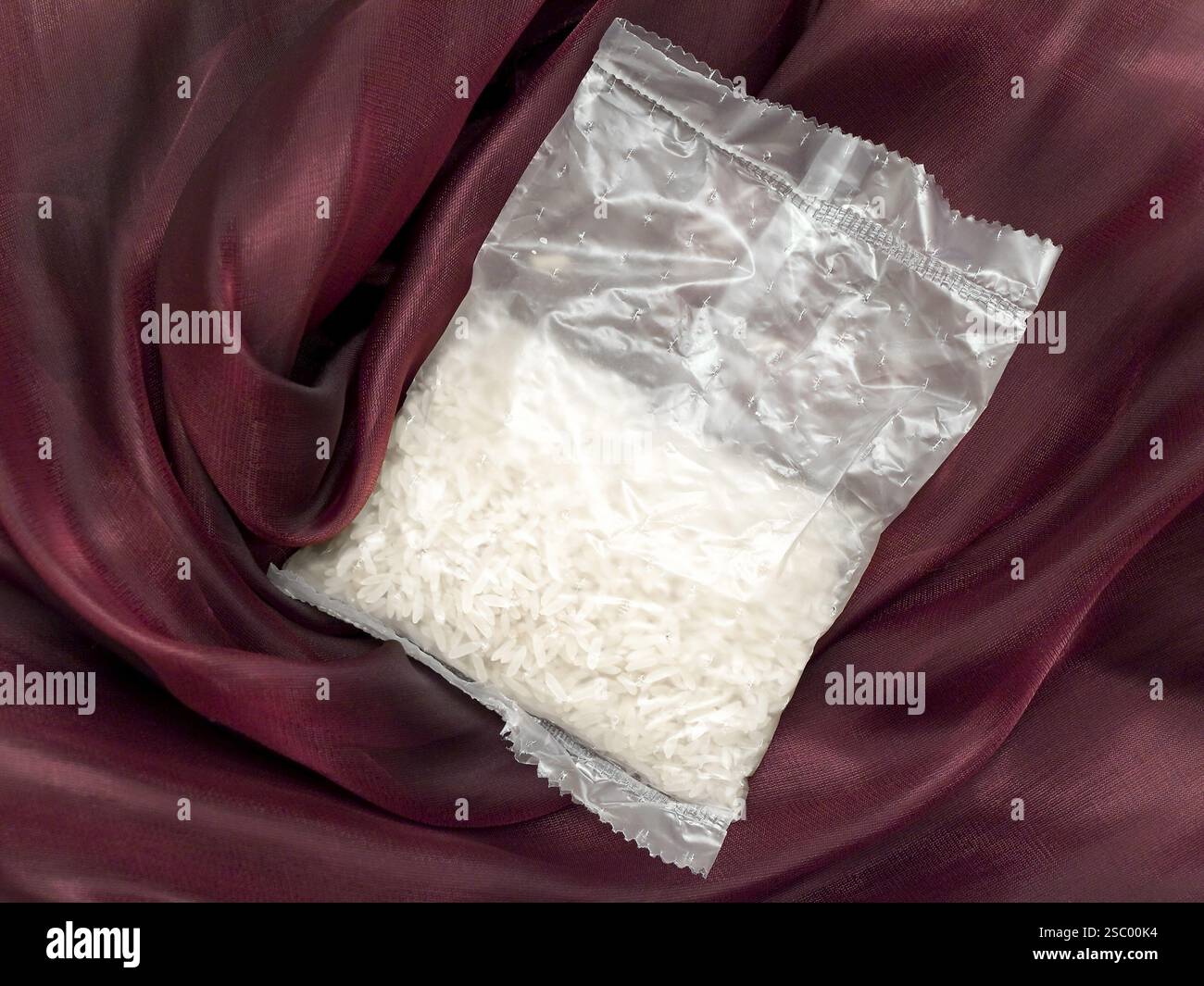 White rice pack at the burgundy textile Stock Photo - Alamy