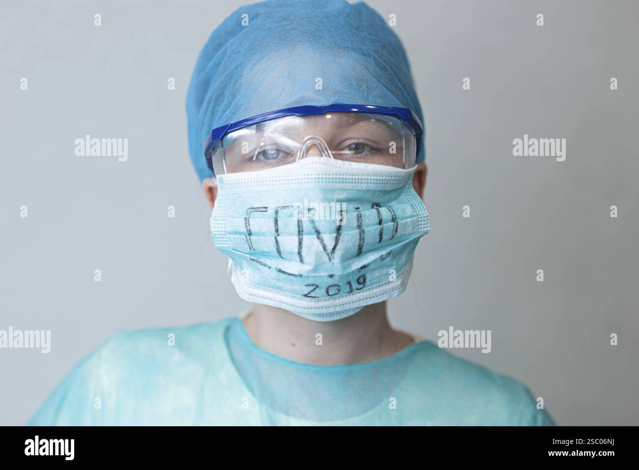 Healthcare worker with a mask labeled COVID-19 and goggles, conveying ...
