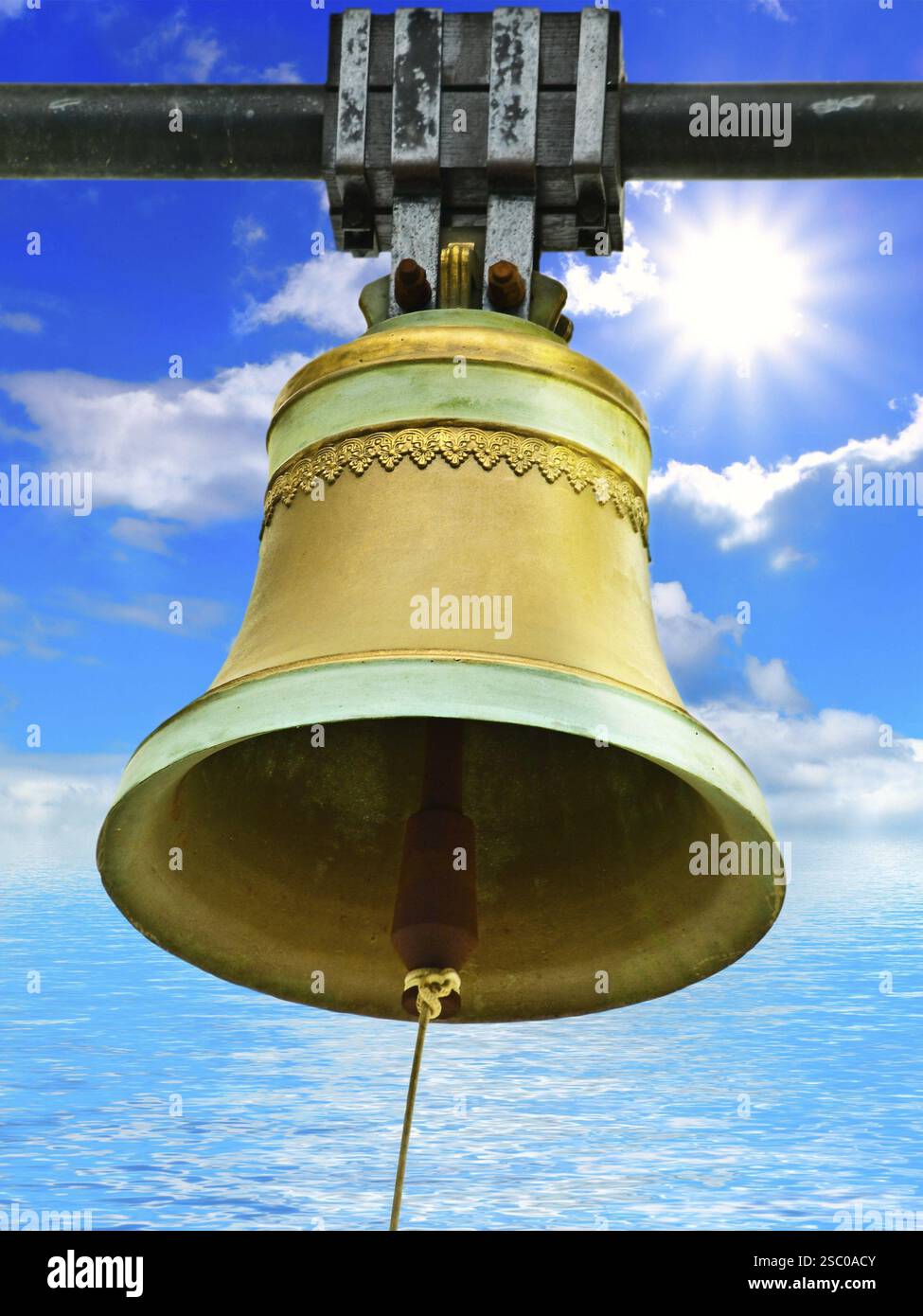 Big Bronze Bell Against The Water And Blue Sky With Sun Stock Photo - Alamy