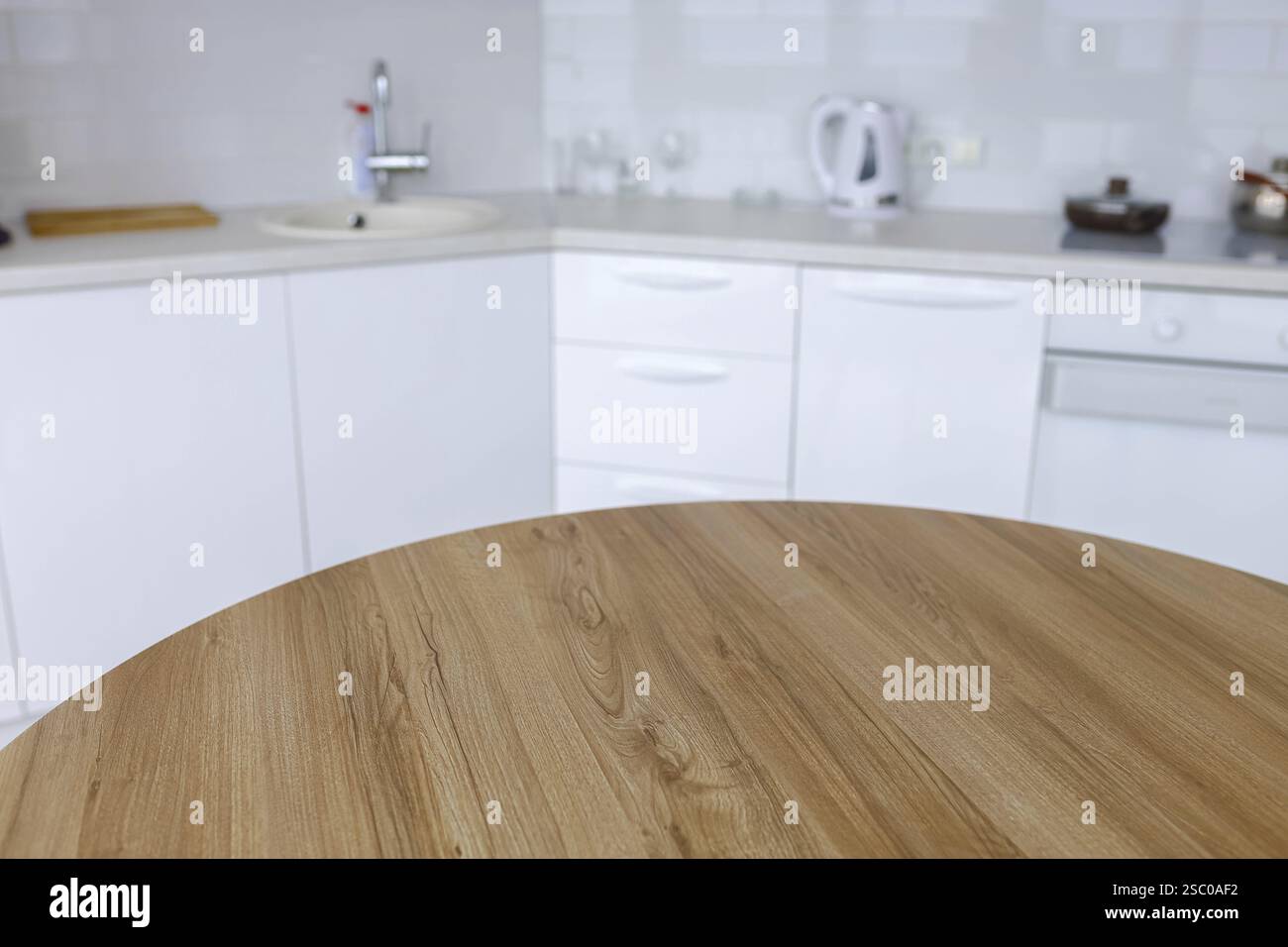 Wooden table surface in a modern kitchen setting with appliances Stock ...