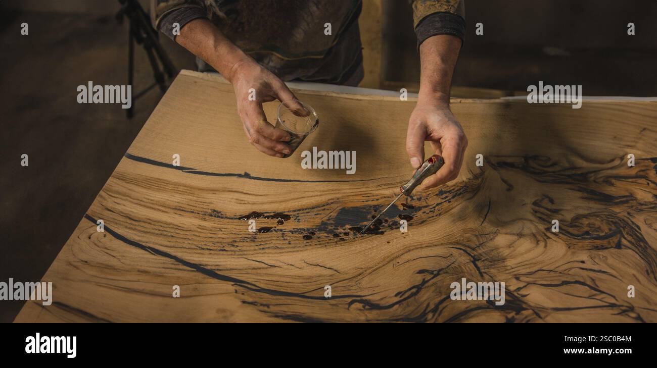 Artisan working on a detailed wooden tabletop, enhancing intricate ...