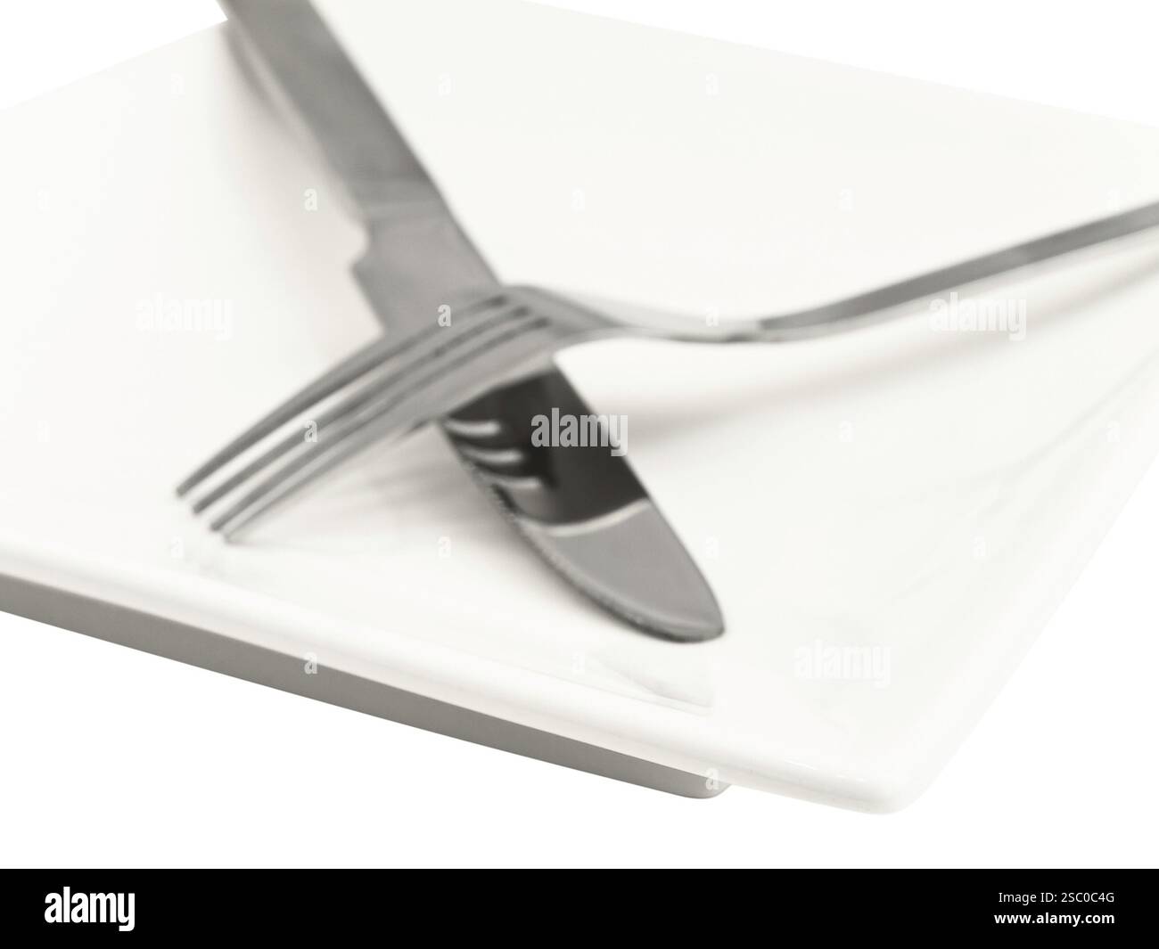 Crossing knife and fork at plate against white background Stock Photo ...