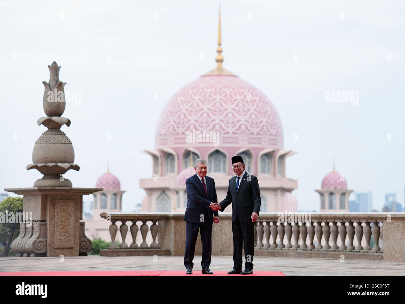 Uzbekistan President Shavkat Mirziyoyev, left, and Malaysian Prime ...
