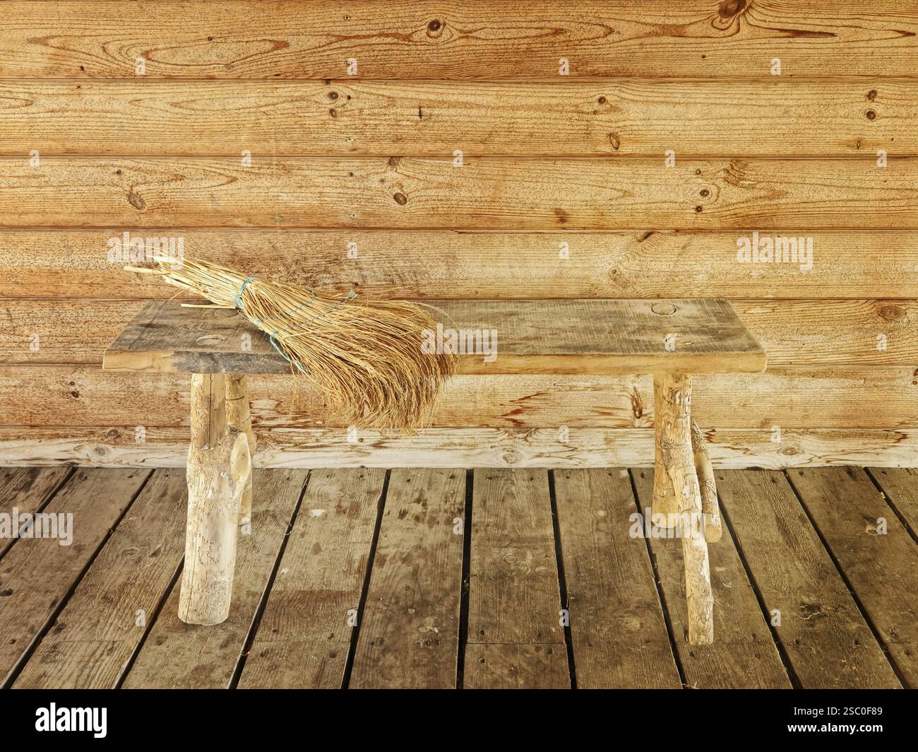 Bench and broom over it against wooden wall Stock Photo - Alamy