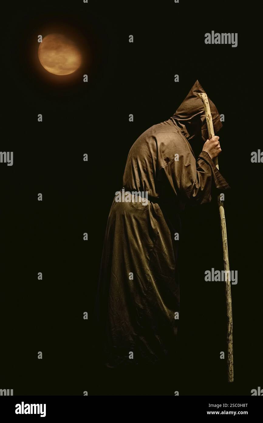 Monk with stick at night Stock Photo - Alamy