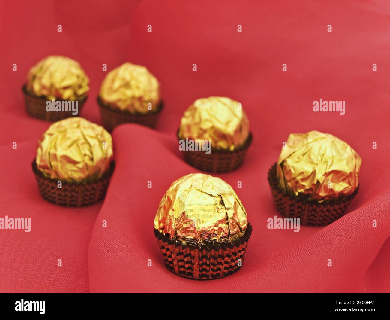 Confection In Golden Candy Wrapper At Red Textile Background Stock ...