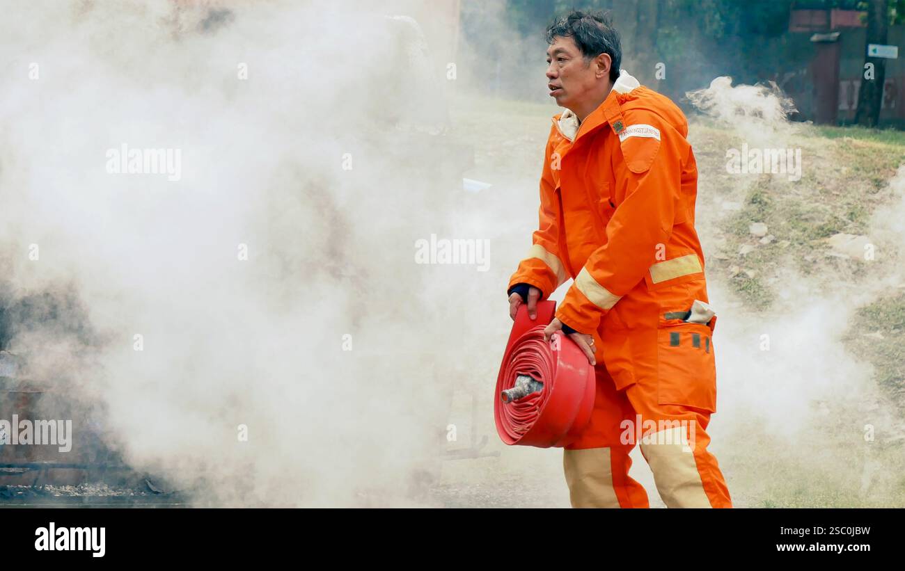 Firefighter fighting with flame using fire hose chemical water foam ...