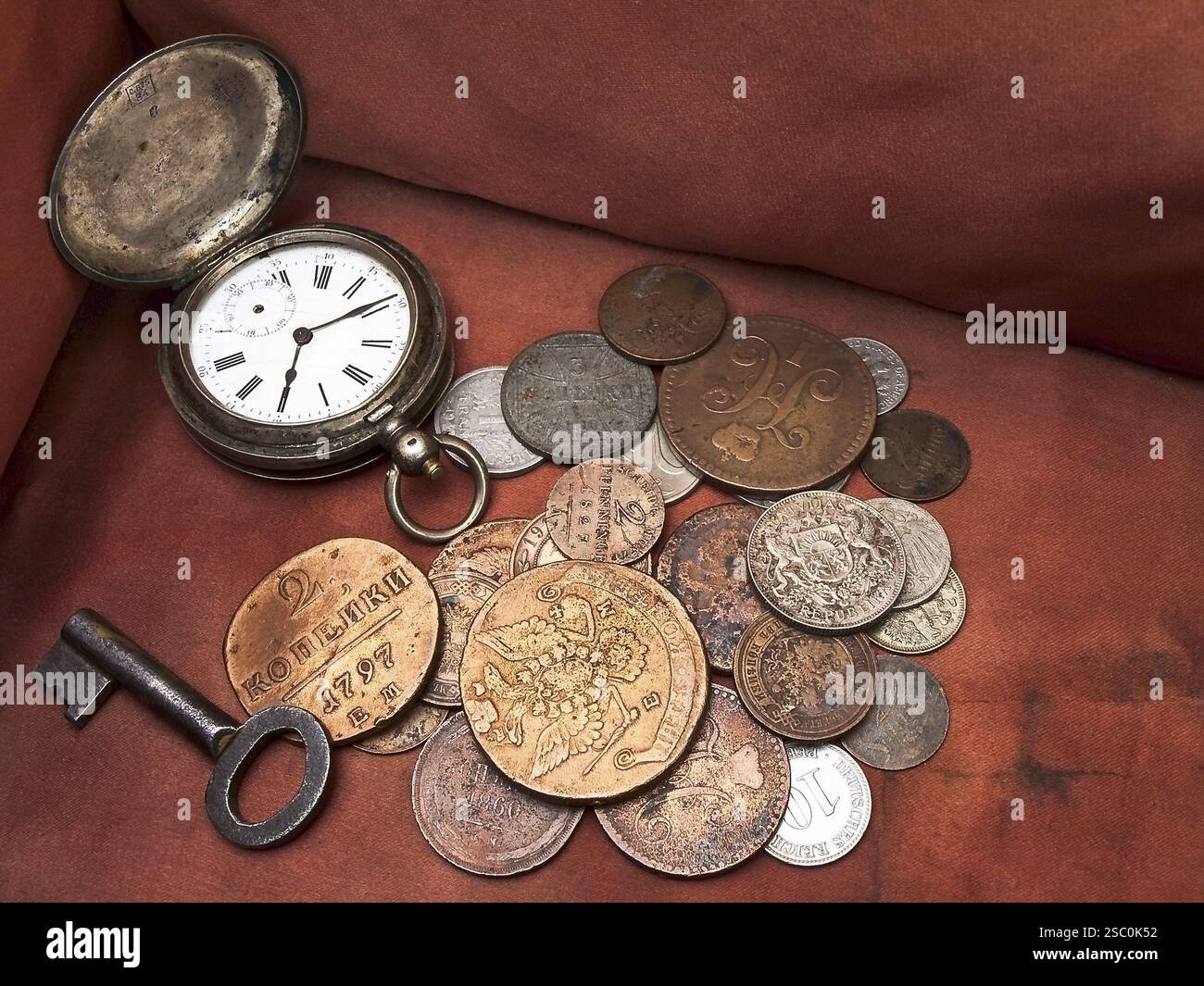 Old clock, key and coins in chest Stock Photo - Alamy