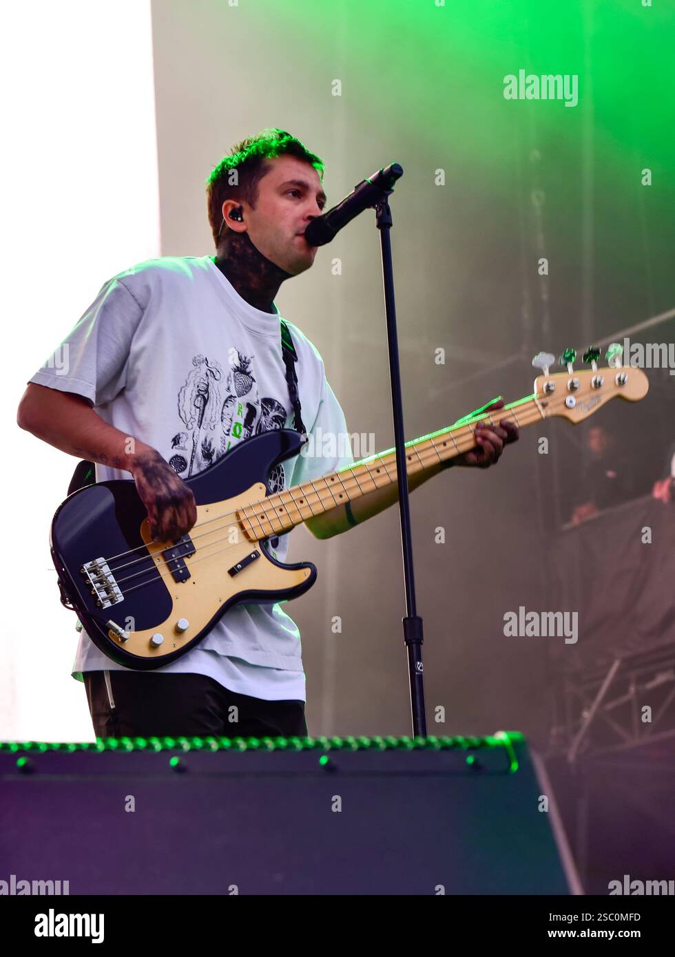 Tyler Joseph of Twenty One Pilots playing the bass guitar on stage at ...