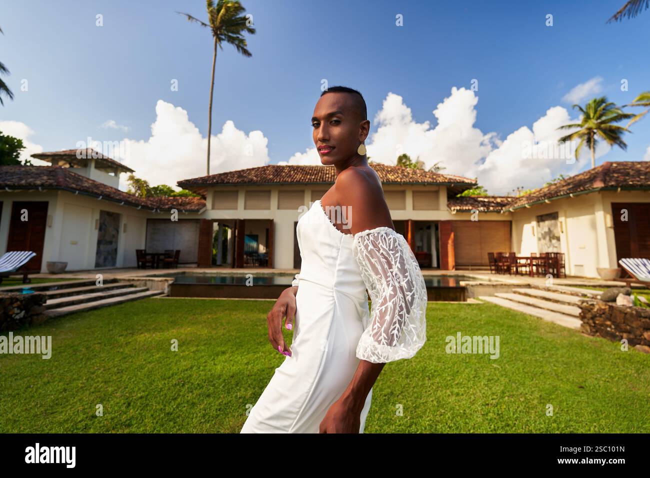 Ambiguous gender fluid ethnic black person in white dress poses ...