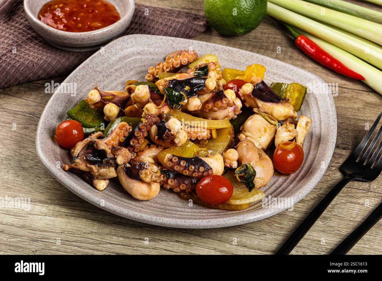Roasted octopus with vegetables, spices and oil Stock Photo - Alamy