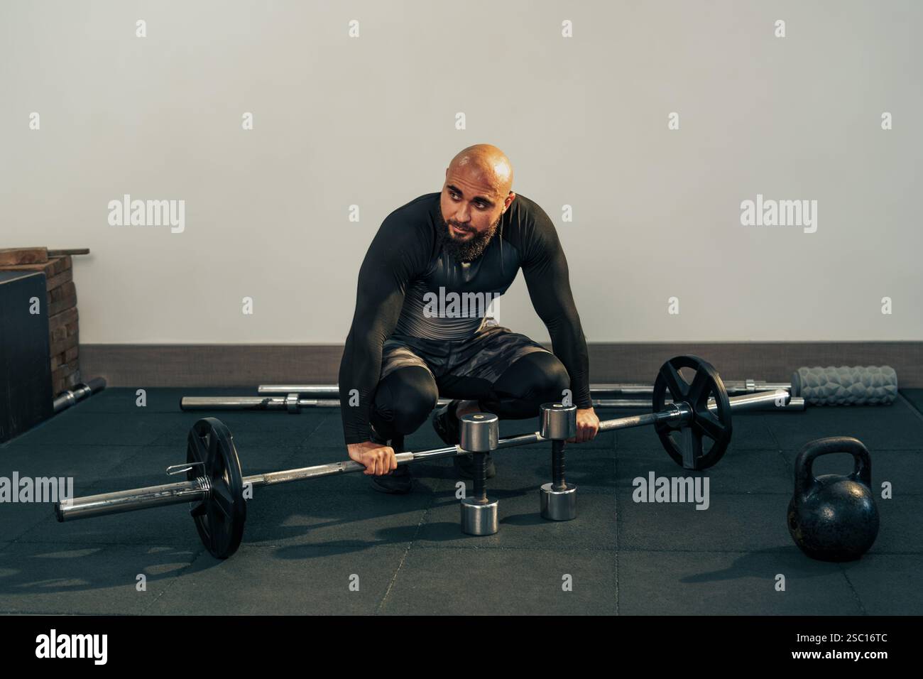 Fitness enthusiast engaged in strength training with weights in a gym ...