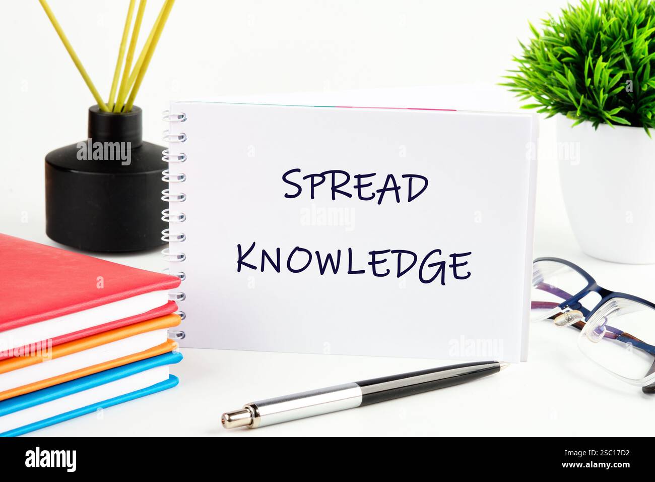 A motivational note encourages spreading knowledge, placed on a desk ...