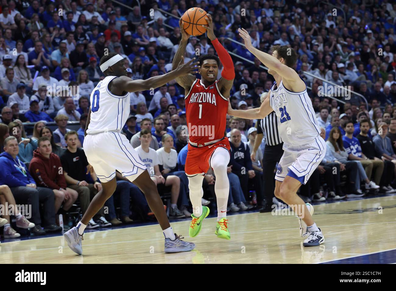 Arizona guard Caleb Love (1) drives between BYU forward Mawot Mag (0 ...