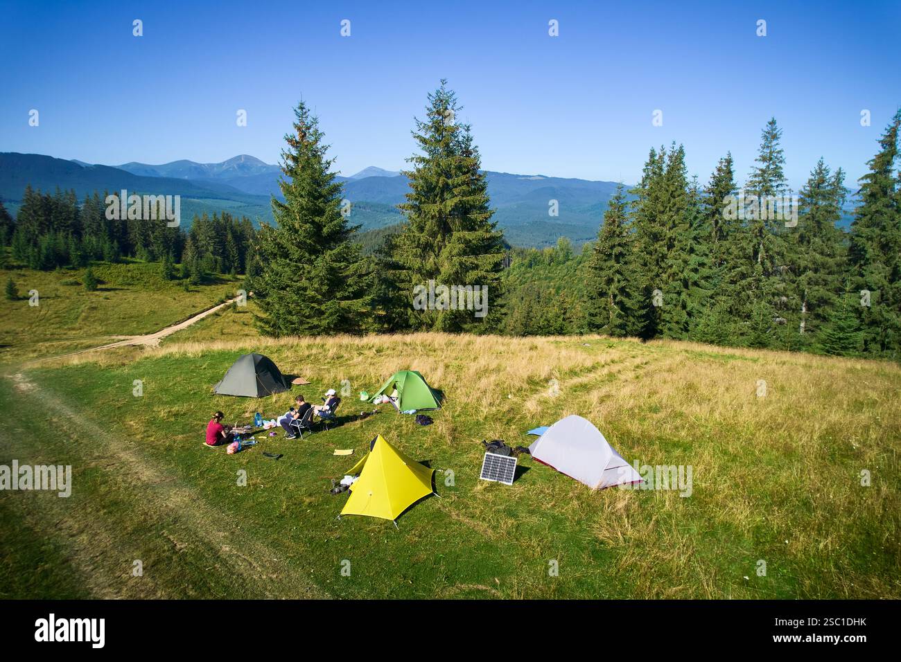 Aerial view campsite in mountains, with several colorful tents on ...