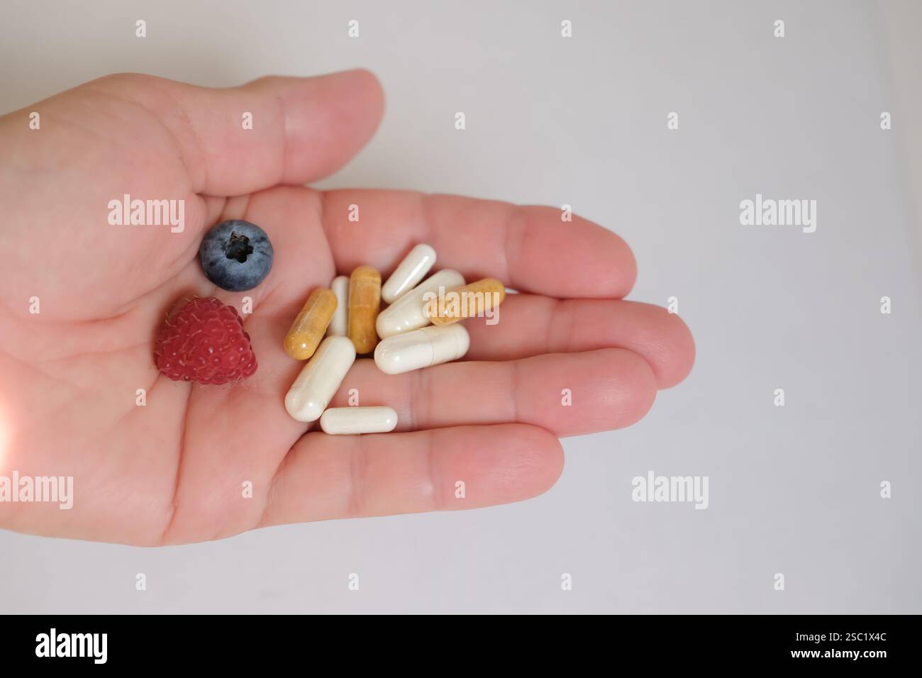 Dietary supplements, and berries in the woman's palm. Vitamins and ...