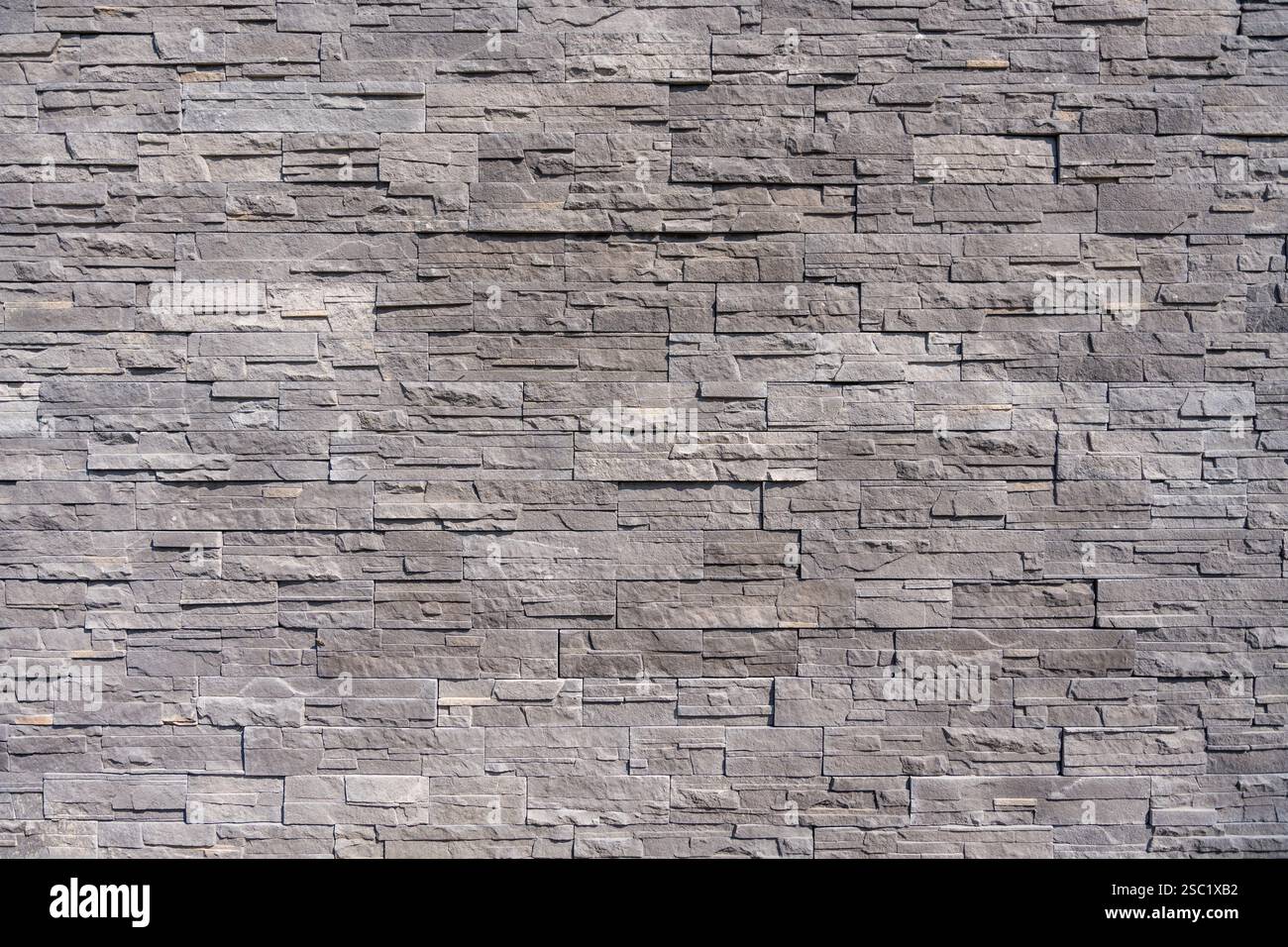 A detailed view of a modern gray stone wall with rectangular patterns ...