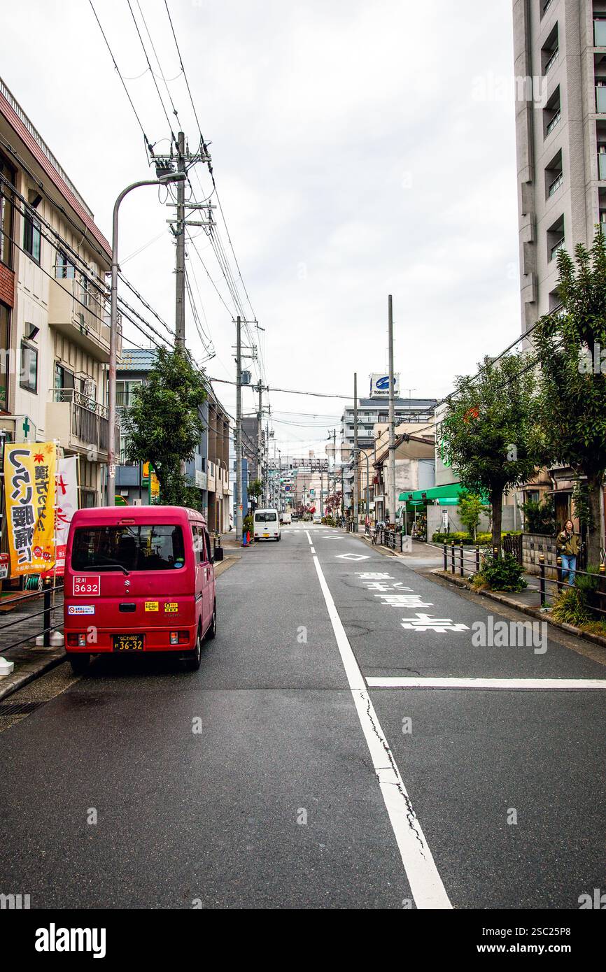 Typical Japanese street in Osaka, Japan lined with shops and apartments ...