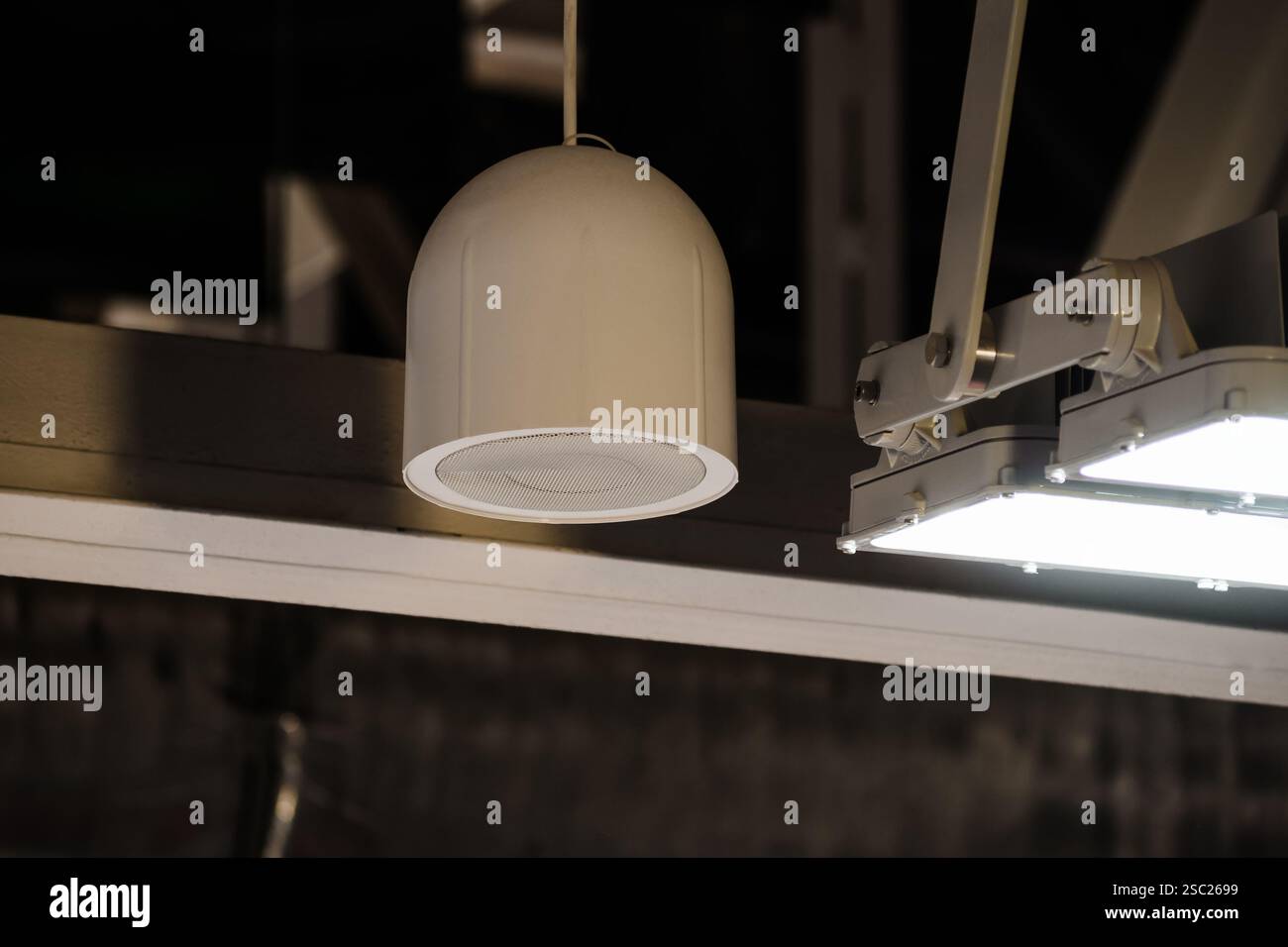 A white bell-shaped fire and other hazard warning audio speaker mounted ...