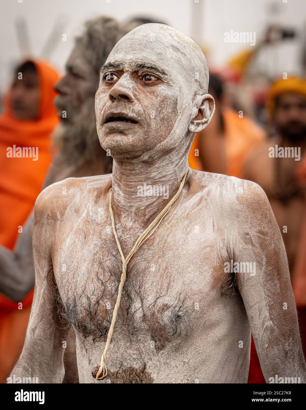 A newly made Naga Sadhu, drenched and ash-covered, walks back to the ...