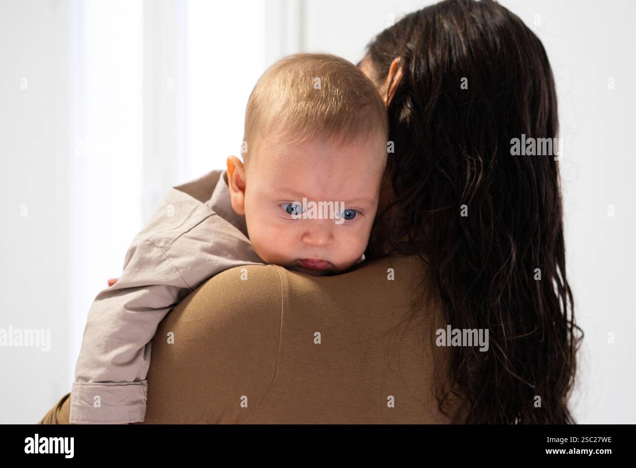 Baby resting on mother's shoulder, creating a tender and intimate ...