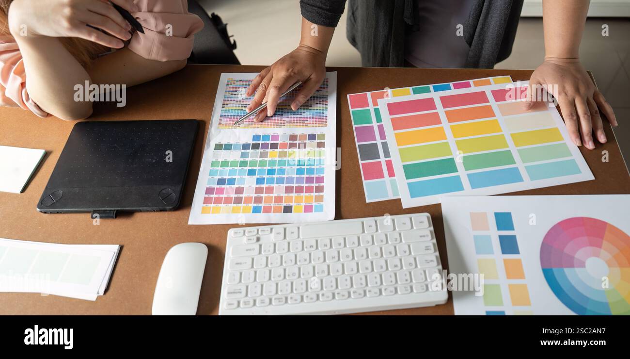 Graphic design team analyzing color palettes and materials in a ...