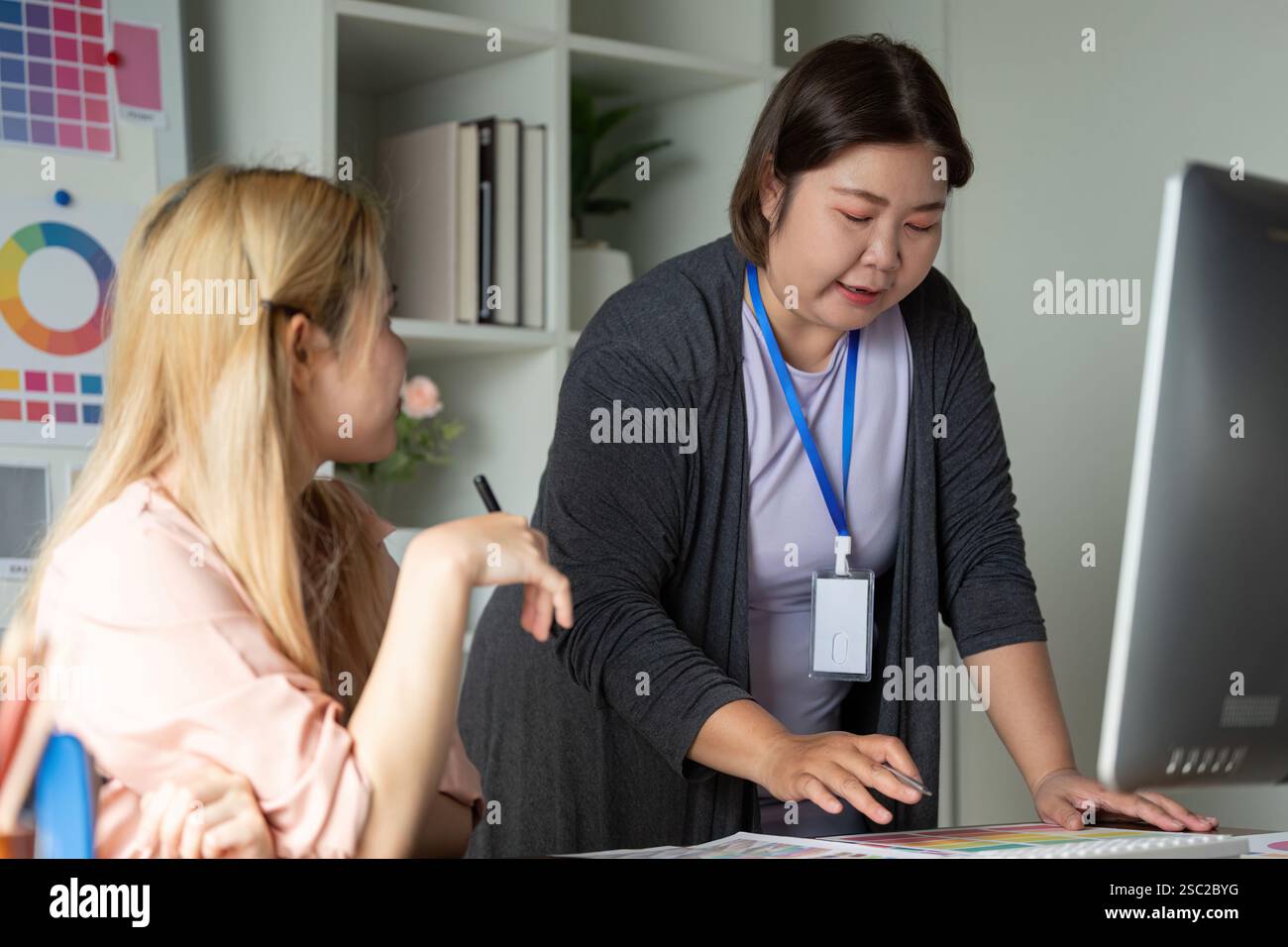 Diverse graphic designer presenting design concepts to a teammate at ...
