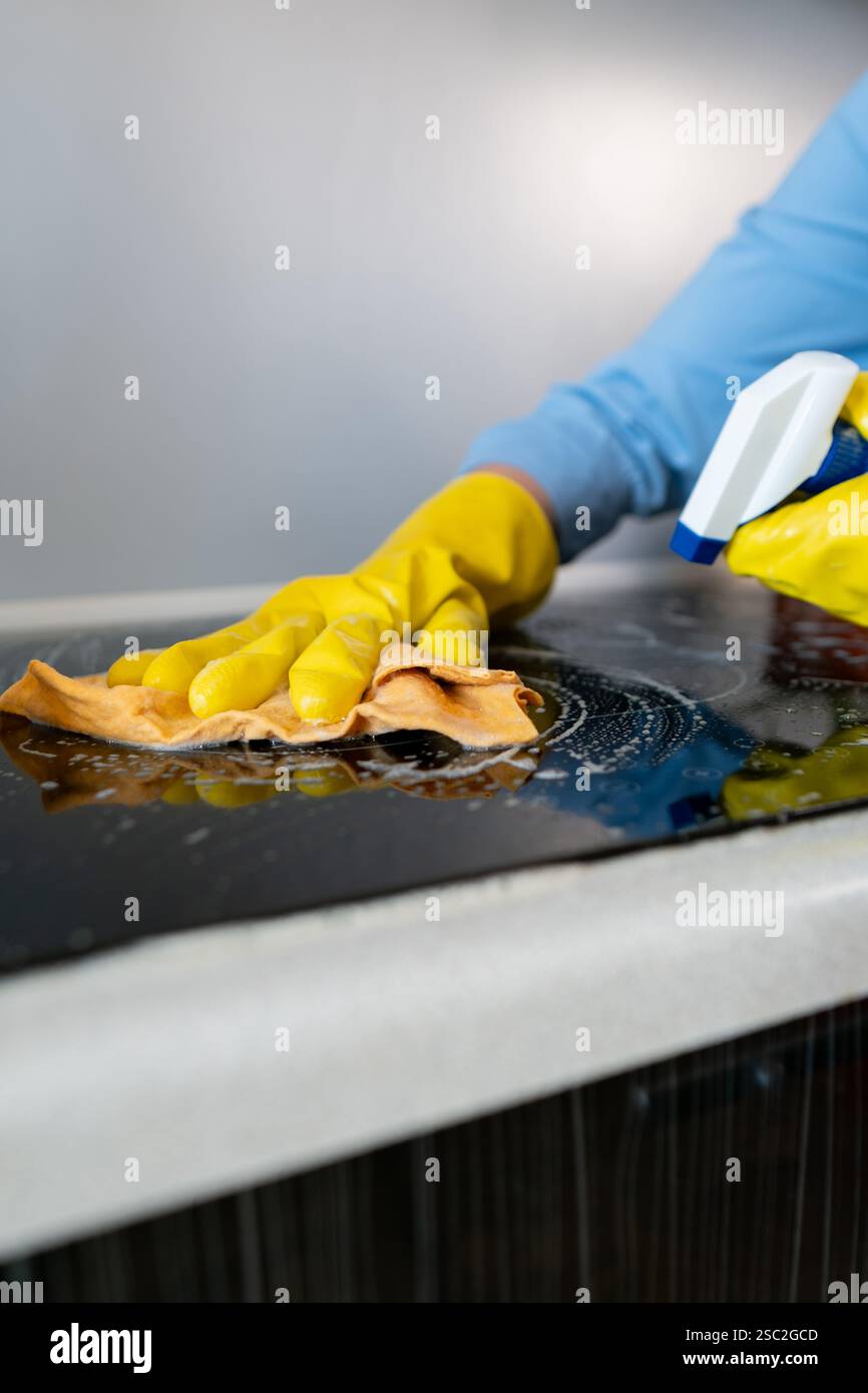 The path to cleanliness: woman cleans the stove, preparing her home for ...