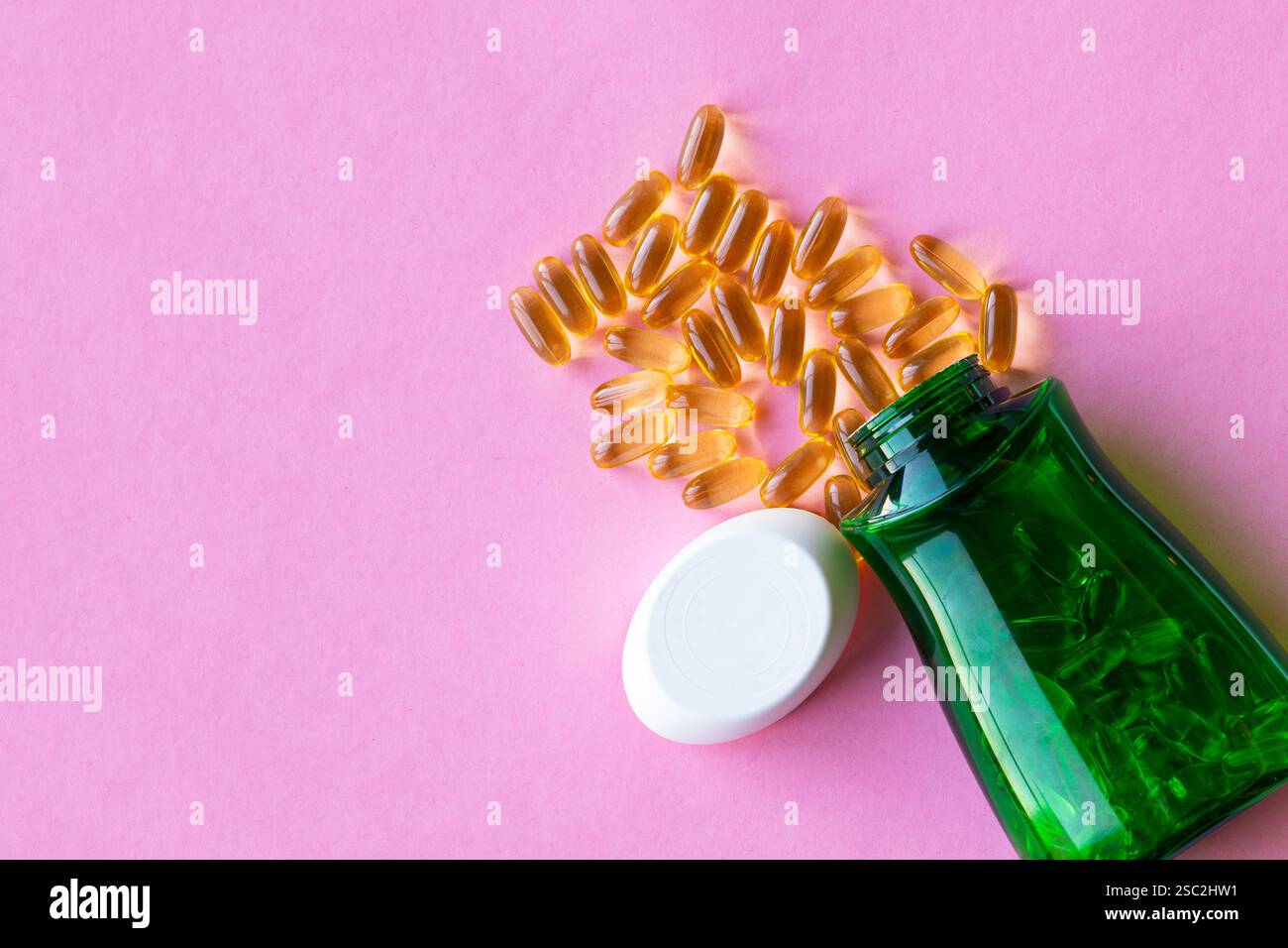 A commercial shot featuring a green pill bottle container with a bunch ...