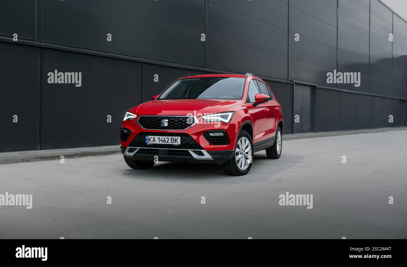 Red SEAT Ateca in front of modern building. Front three quarter view of ...