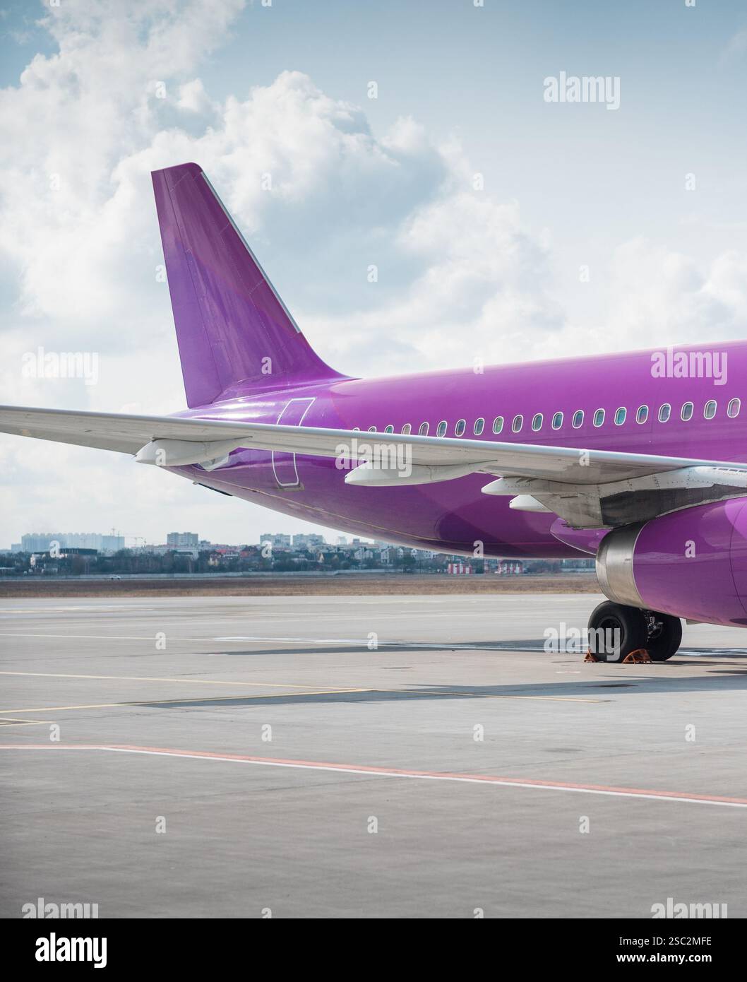 Rear part of purple aircraft parked on the apron at the airport. Tail ...