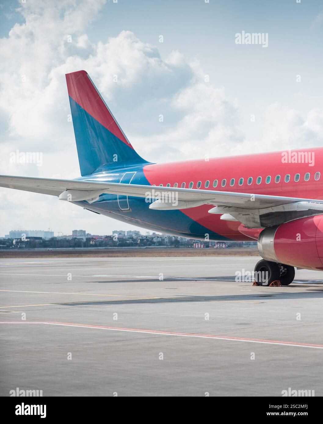 Tail section of of blush pink aircraft parked on the apron at the ...