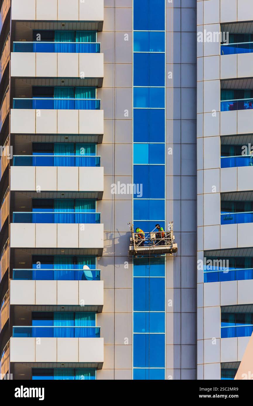 window cleaners in a gondola cleaning the windows of a corporate office ...
