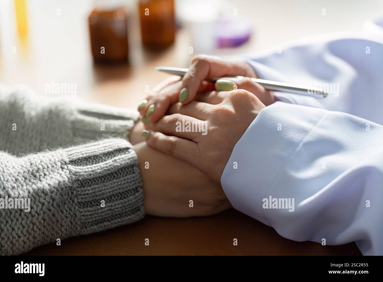 Compassionate Muslim female doctor holding a patient's hands in a ...