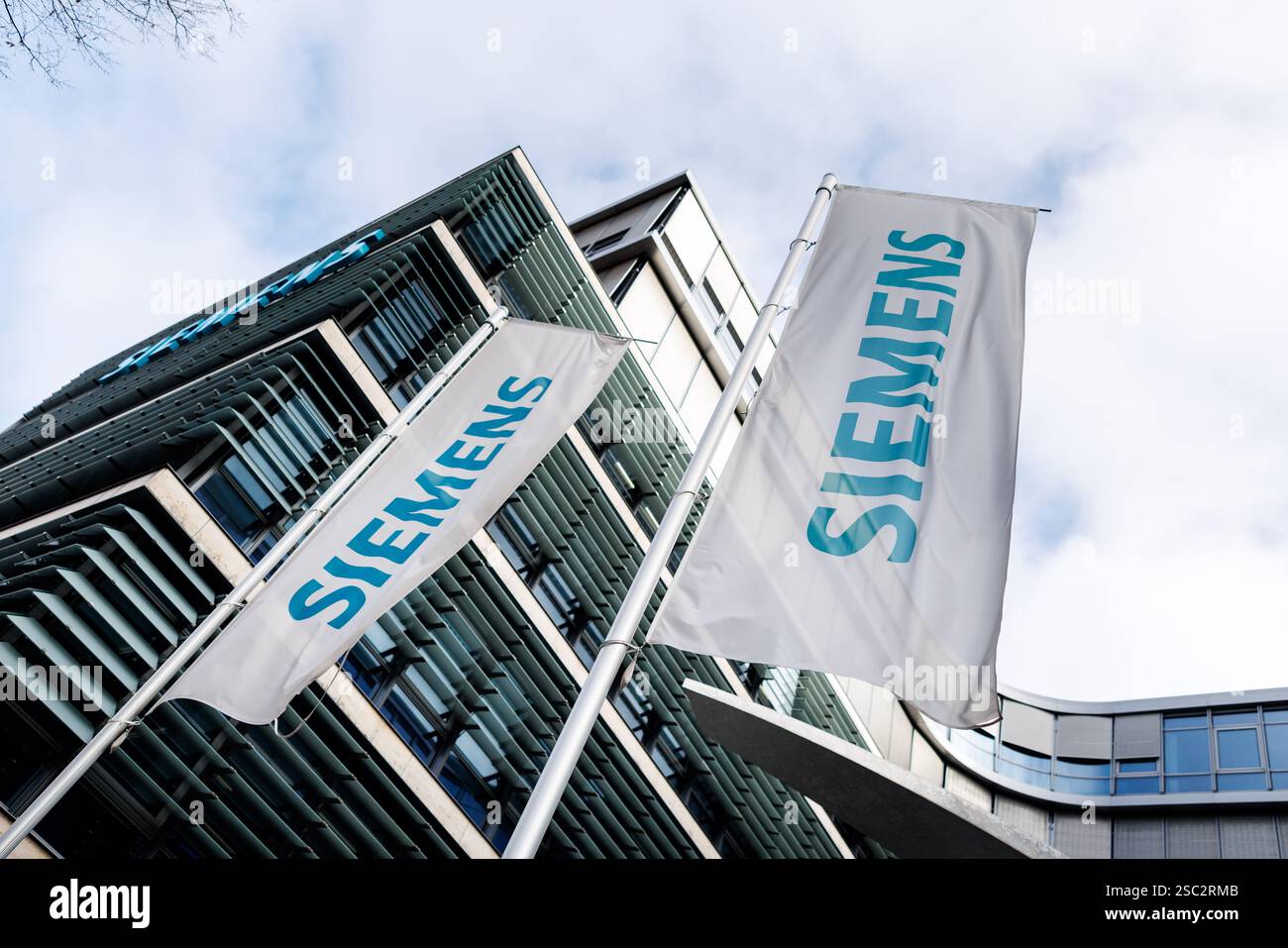 04 February 2025, Bavaria, Munich: The Siemens lettering and logo can be seen on flags in front ...