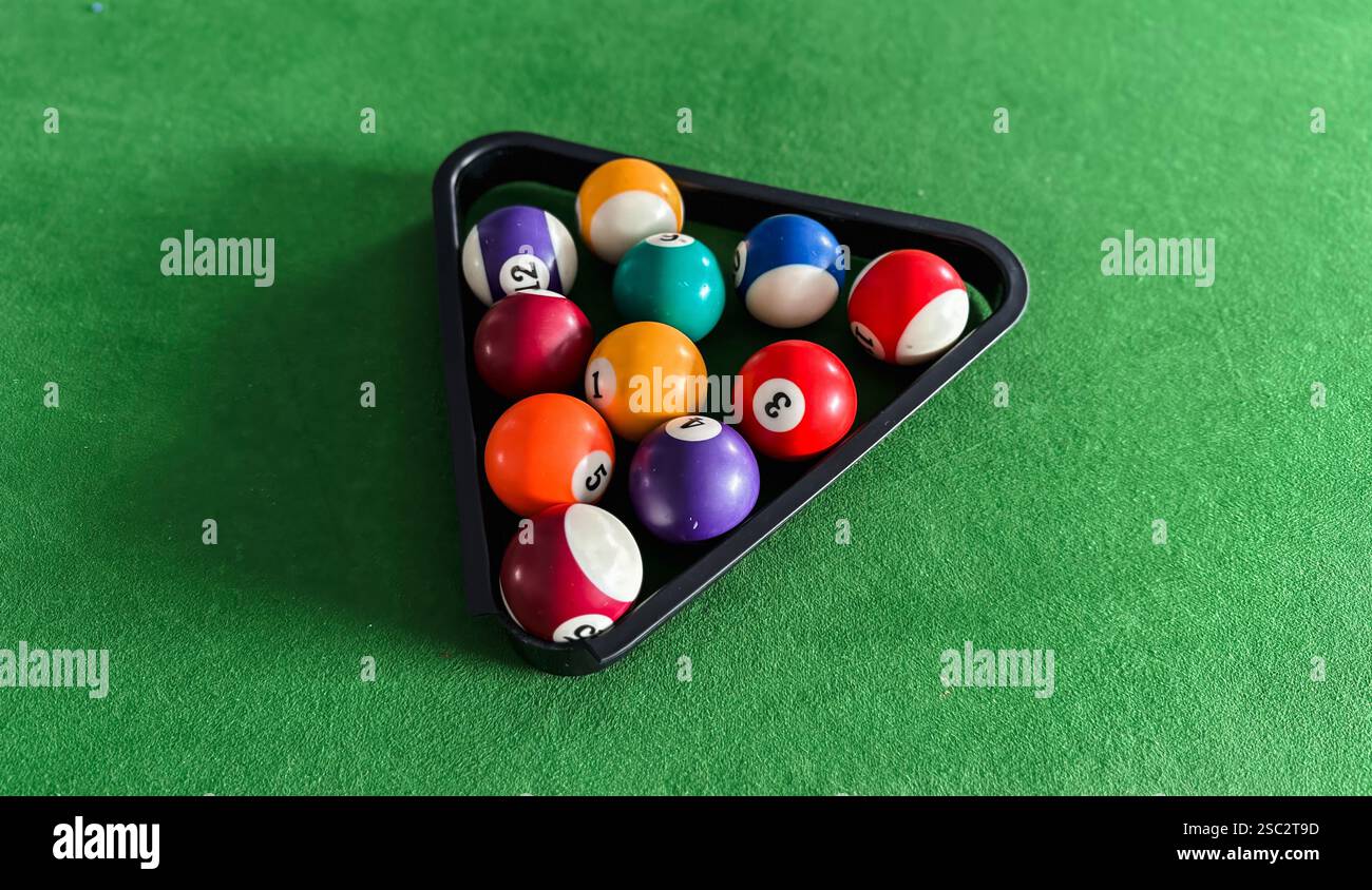 A black triangular tray with nine balls on it. The balls are numbered 1 ...