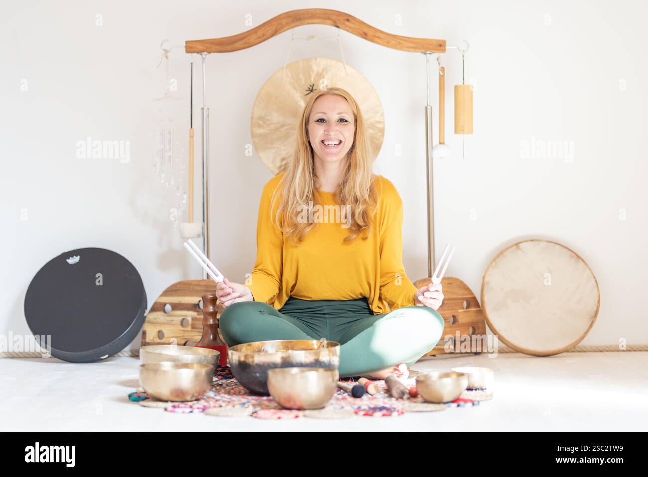 Young cheerful woman performing music therapy session with traditional ...
