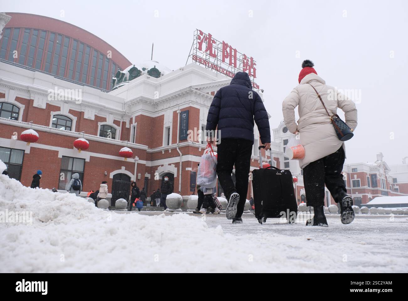 Passengers brave the snowfall to catch the train in Shenyang City ...